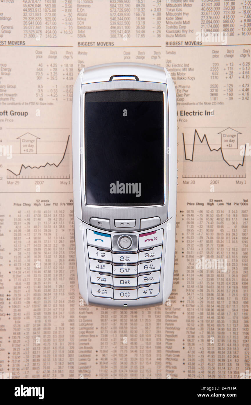 Mobile phone on a financial newspaper Stock Photo - Alamy