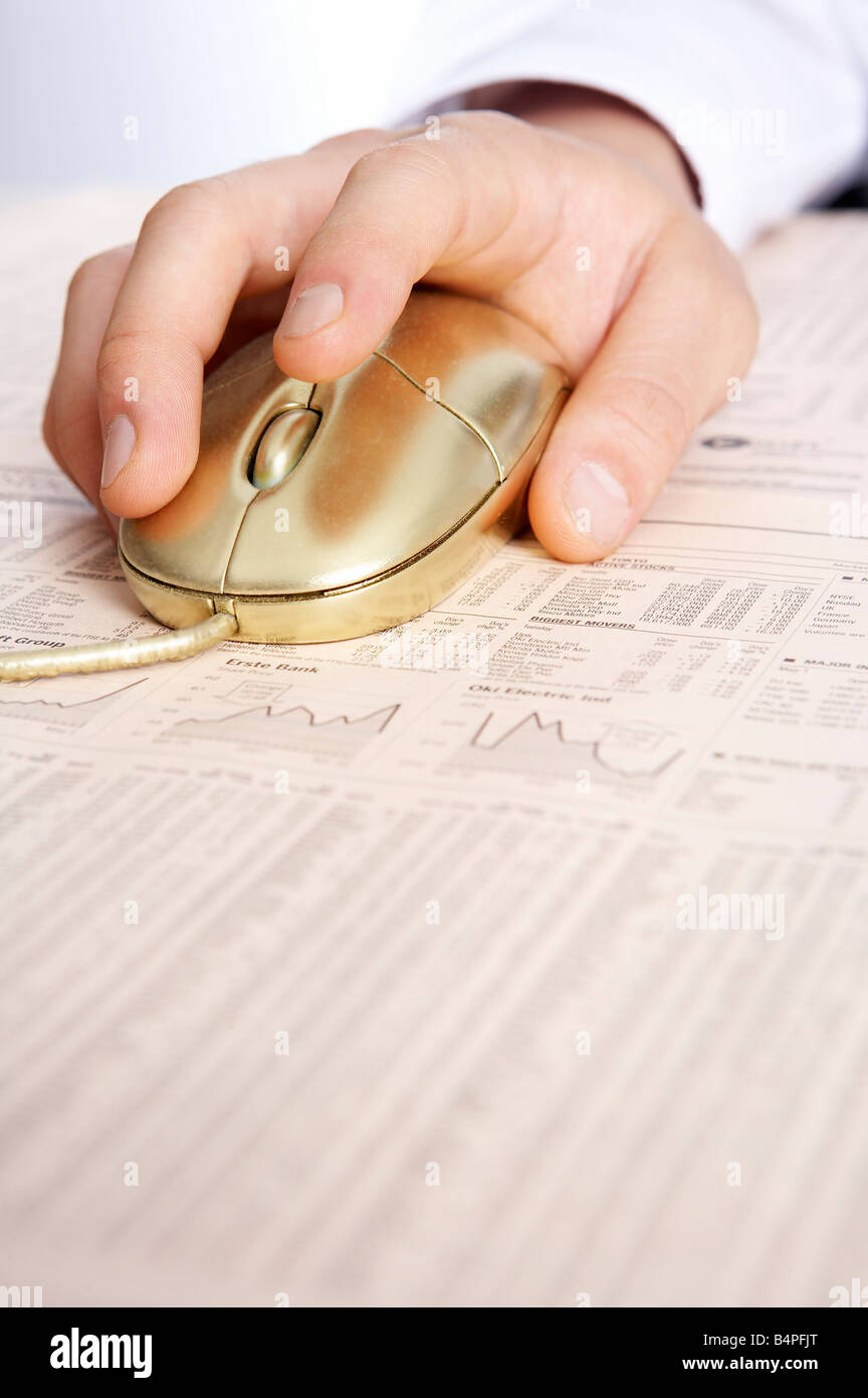 Man using computer mouse on financial newspaper Stock Photo - Alamy