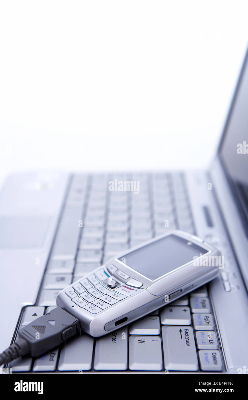 Mobile phone plugged into laptop, close-up Stock Photo - Alamy