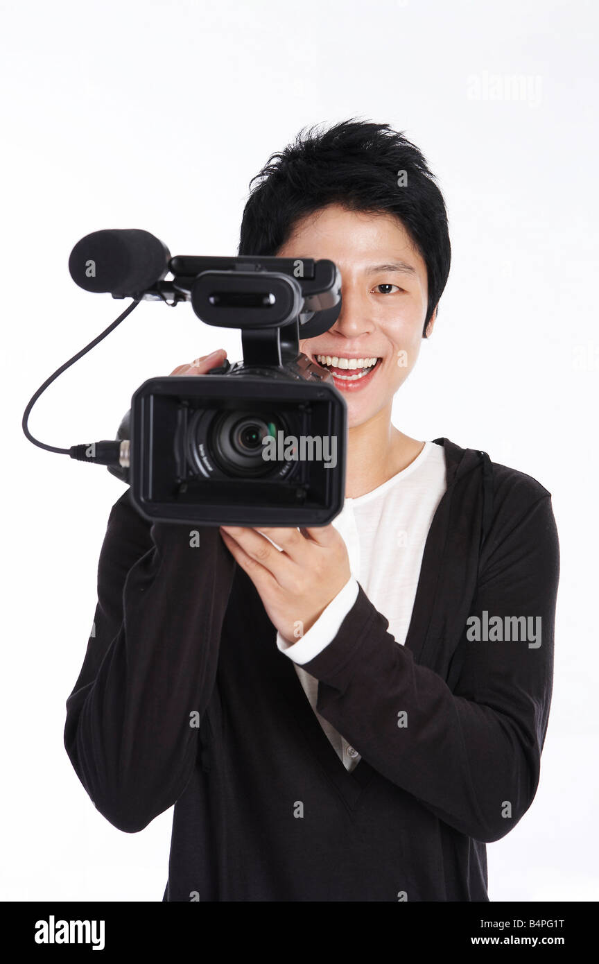 Young man using video camera, portrait Stock Photo - Alamy