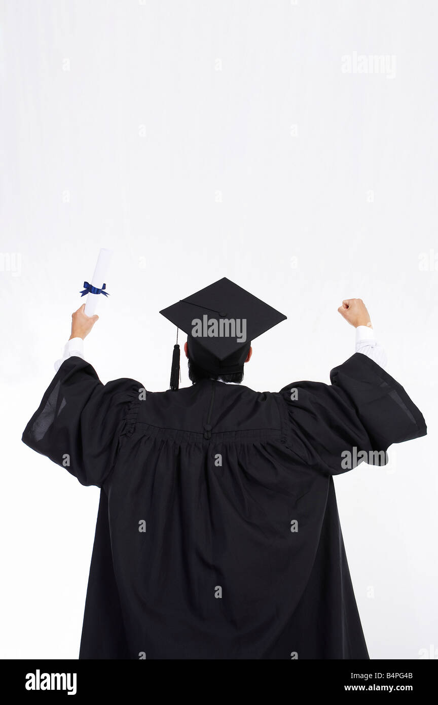 Young man in graduation gown with certificate, rear view Stock Photo ...