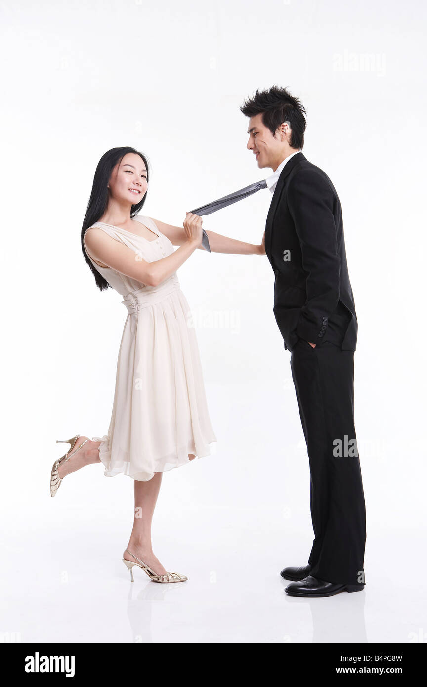 Young woman pulling tie of young man Stock Photo - Alamy