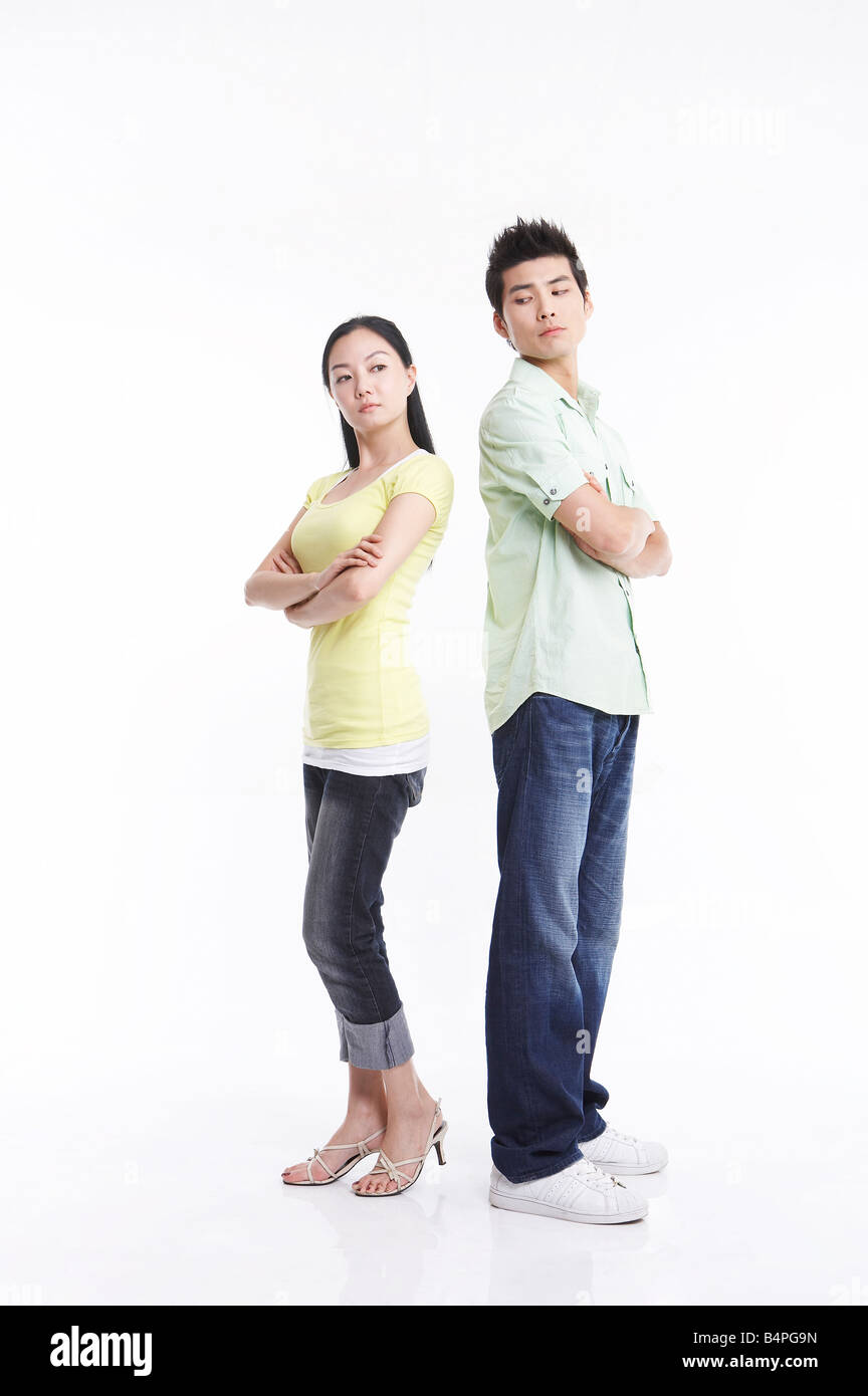 Young couple standing back to back Stock Photo - Alamy