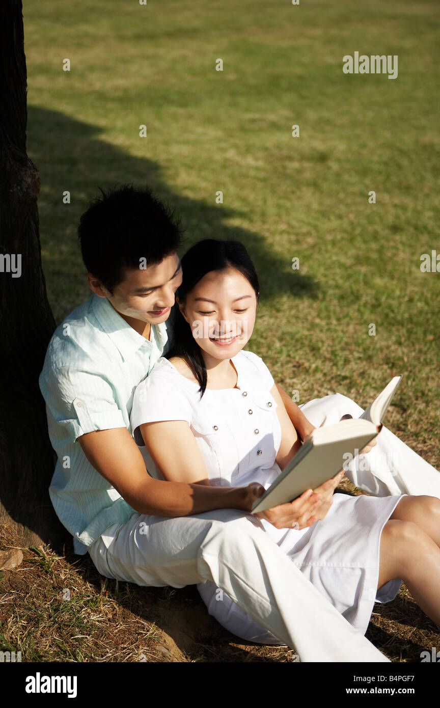 Young couple reading book Stock Photo - Alamy