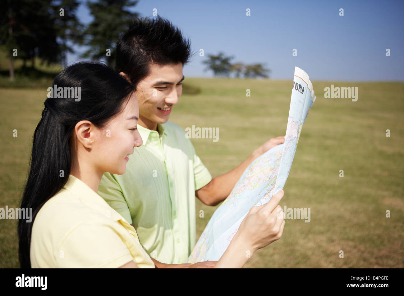 Smiling couple looking at map Stock Photo - Alamy
