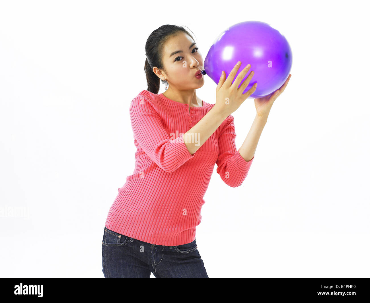 Young woman holding balloon, gesturing Stock Photo - Alamy