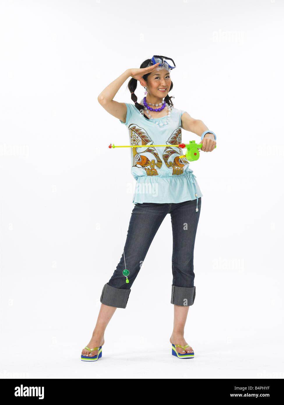 Portrait of a young woman holding fishing rod Stock Photo - Alamy