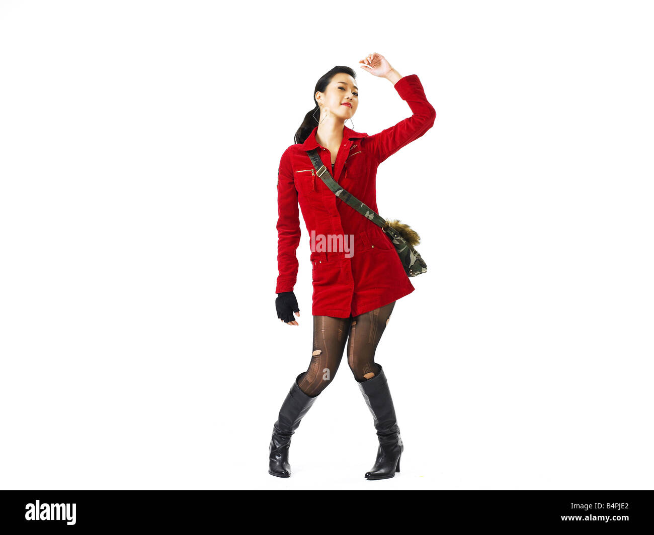Portrait of a young woman carrying shoulder bag against white ...