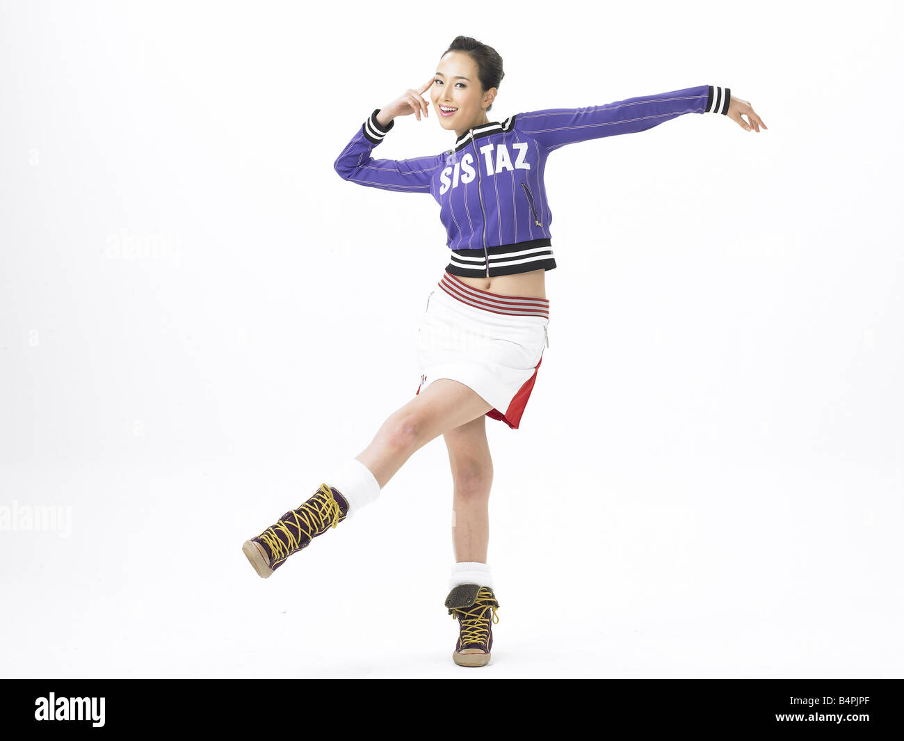 Portrait of a woman standing on one leg against white background Stock ...