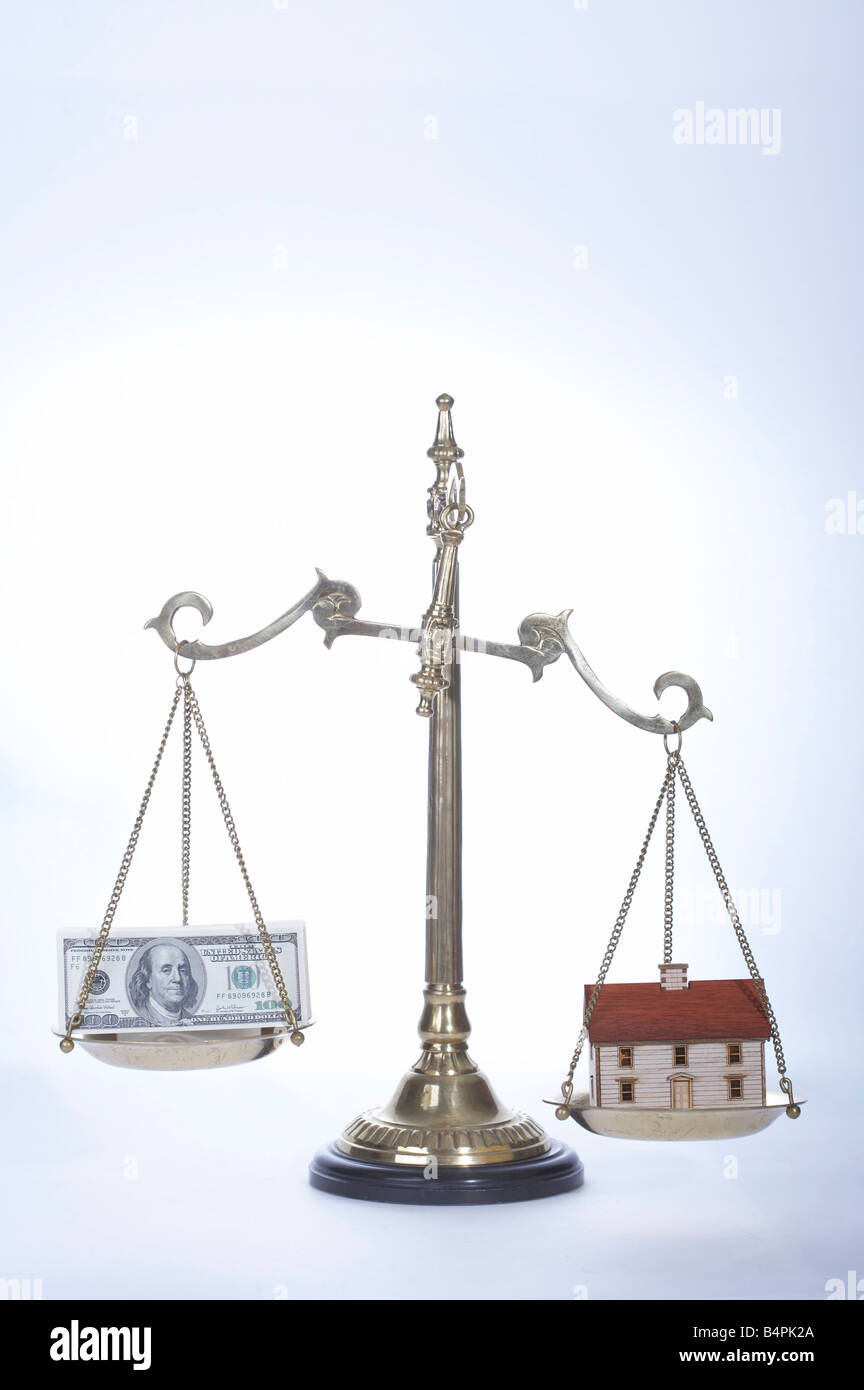 Toy house and bundles on weigh scale Stock Photo - Alamy