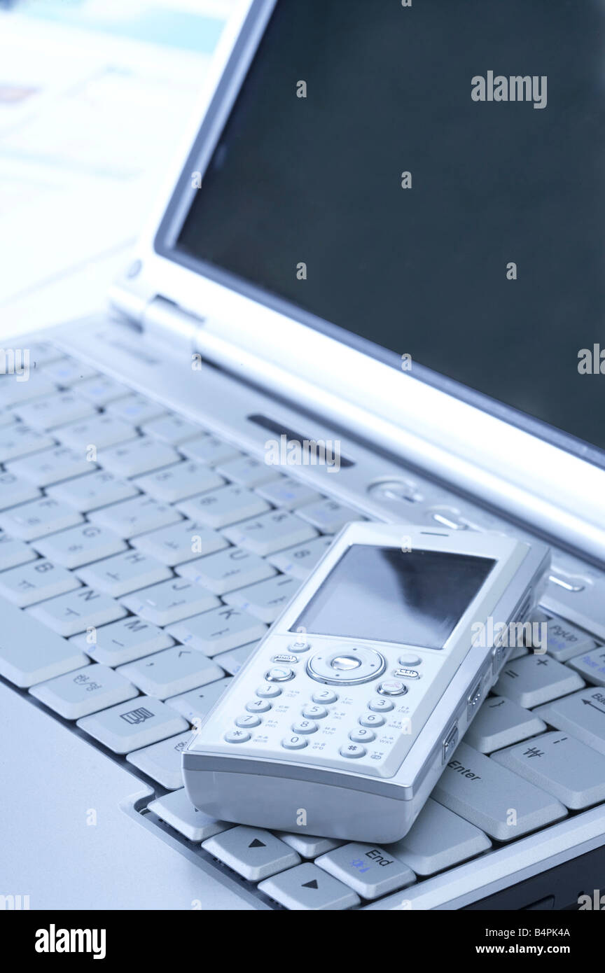 Mobile phone and laptop with financial paper Stock Photo - Alamy