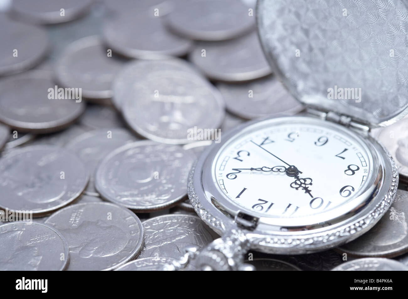 Pocket watch on silver coins Stock Photo - Alamy