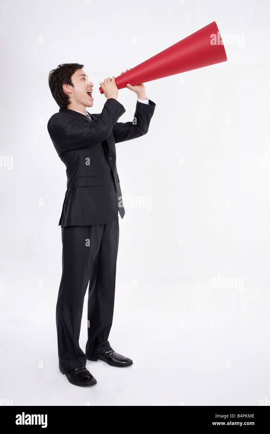 Young man holding megaphone against white background Stock Photo - Alamy