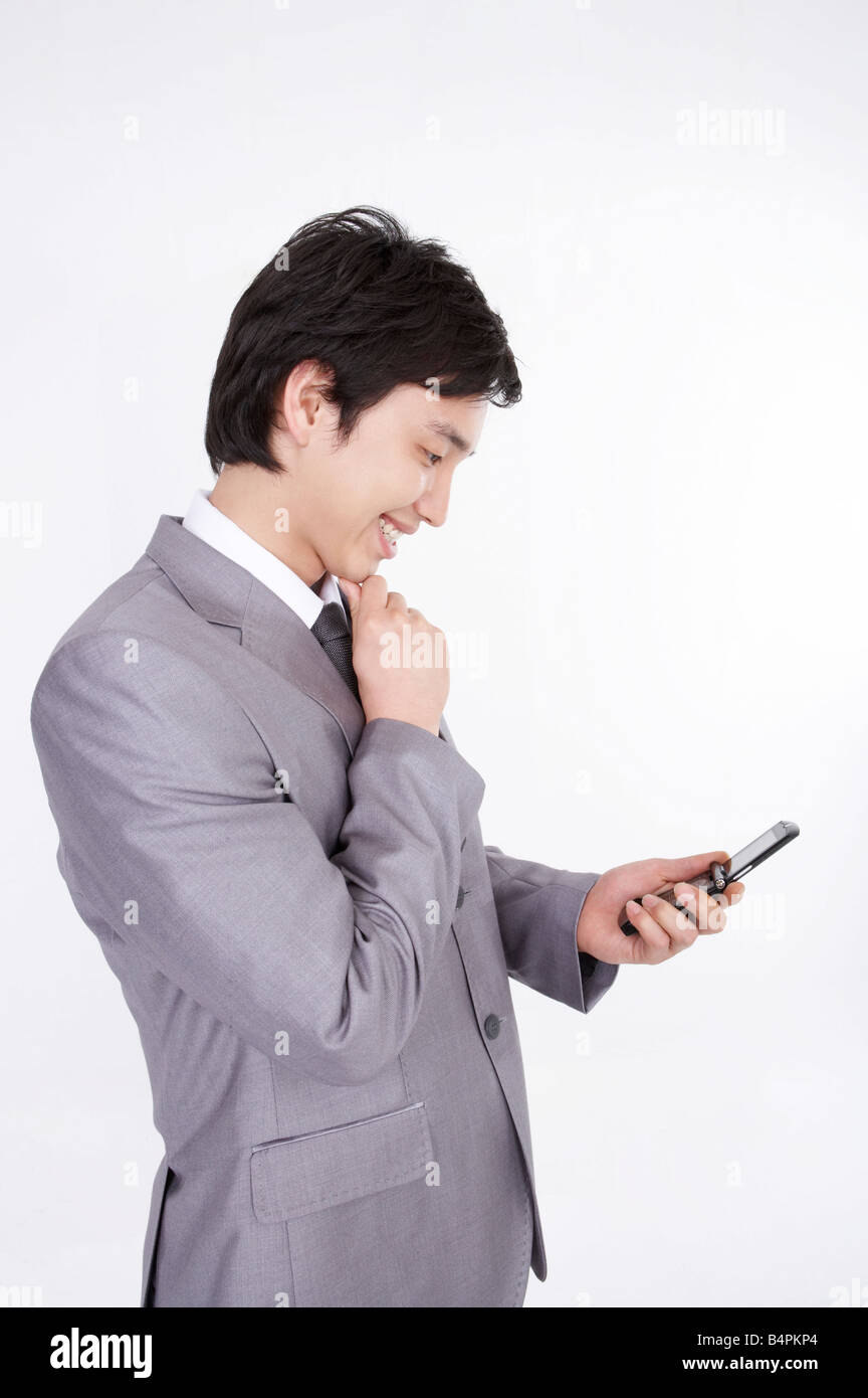 Businessman holding mobile phone reading text message Stock Photo - Alamy