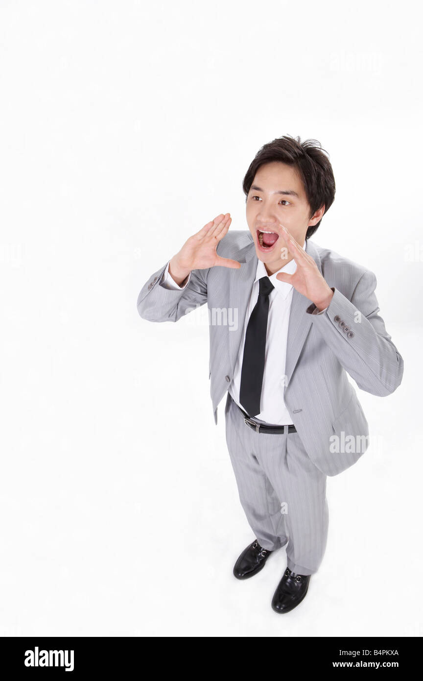 Businessman shouting against white background Stock Photo - Alamy