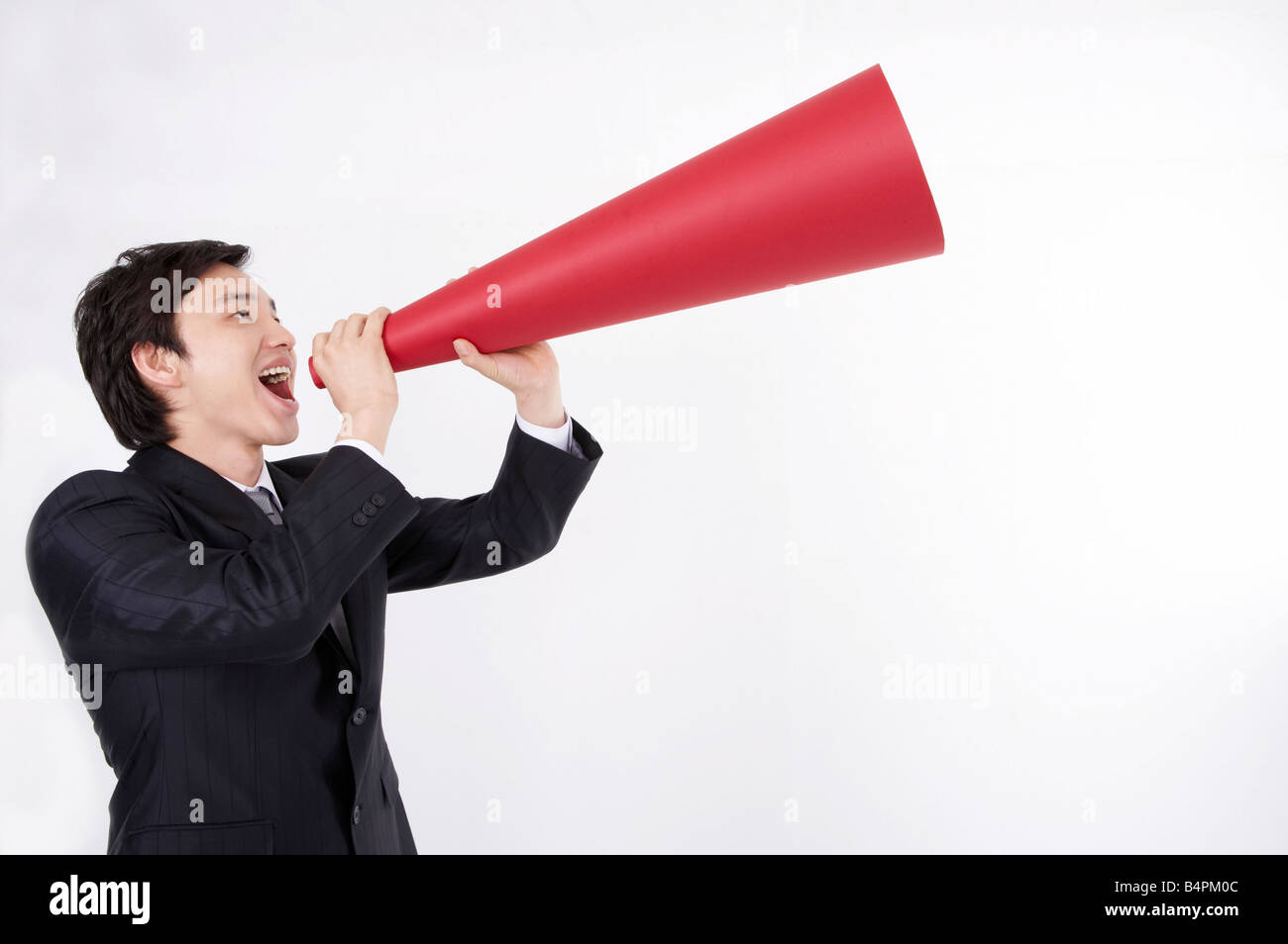 Young man shouting into megaphone against white background Stock Photo ...