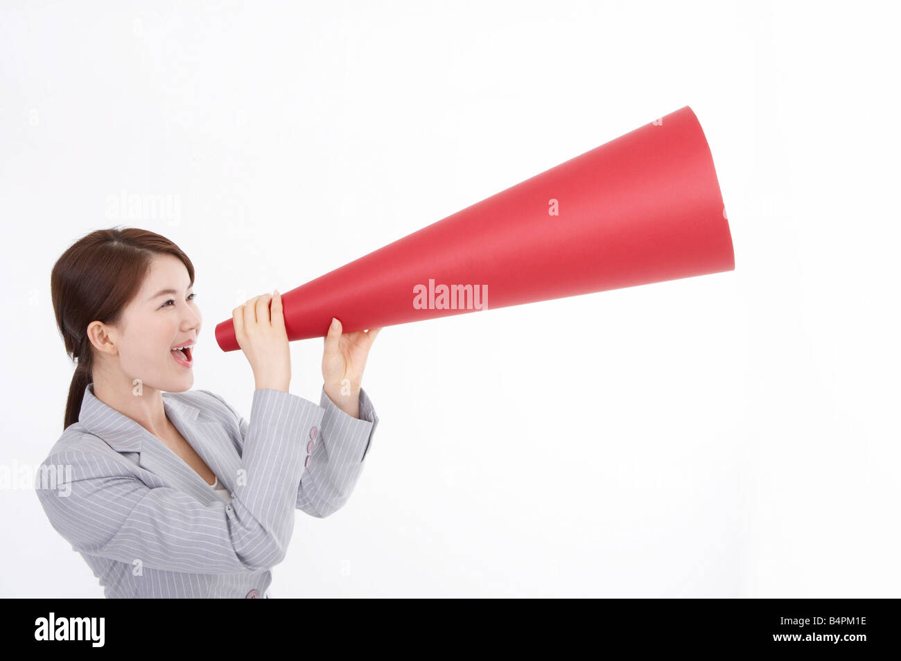 Young woman shouting into megaphone Stock Photo - Alamy