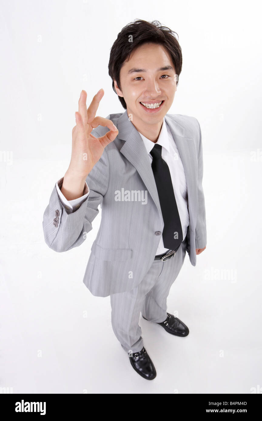 Portrait of a cheerful young businessman with hand sign Stock Photo - Alamy