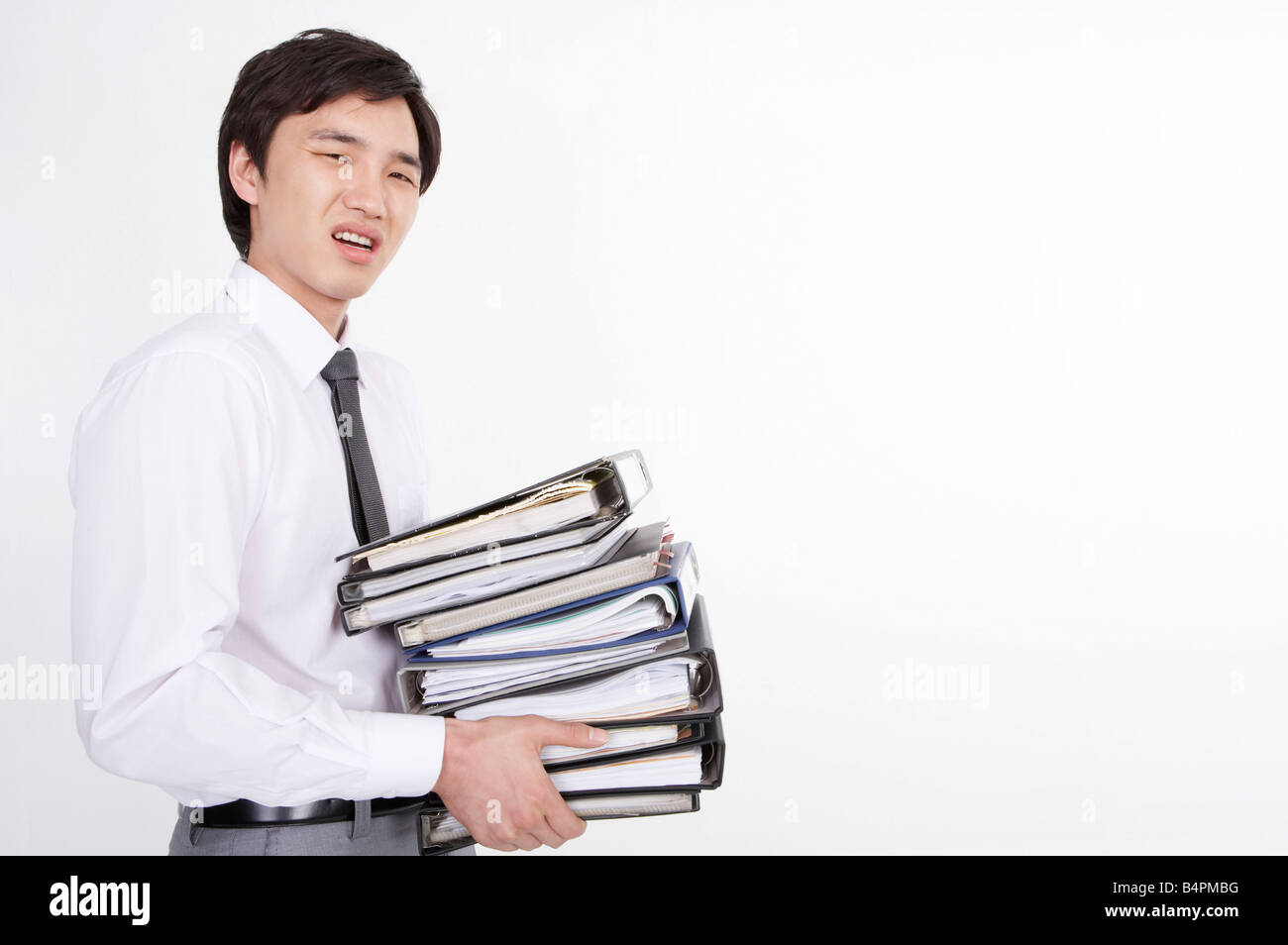 Businessman carrying stacks of files, portrait Stock Photo - Alamy
