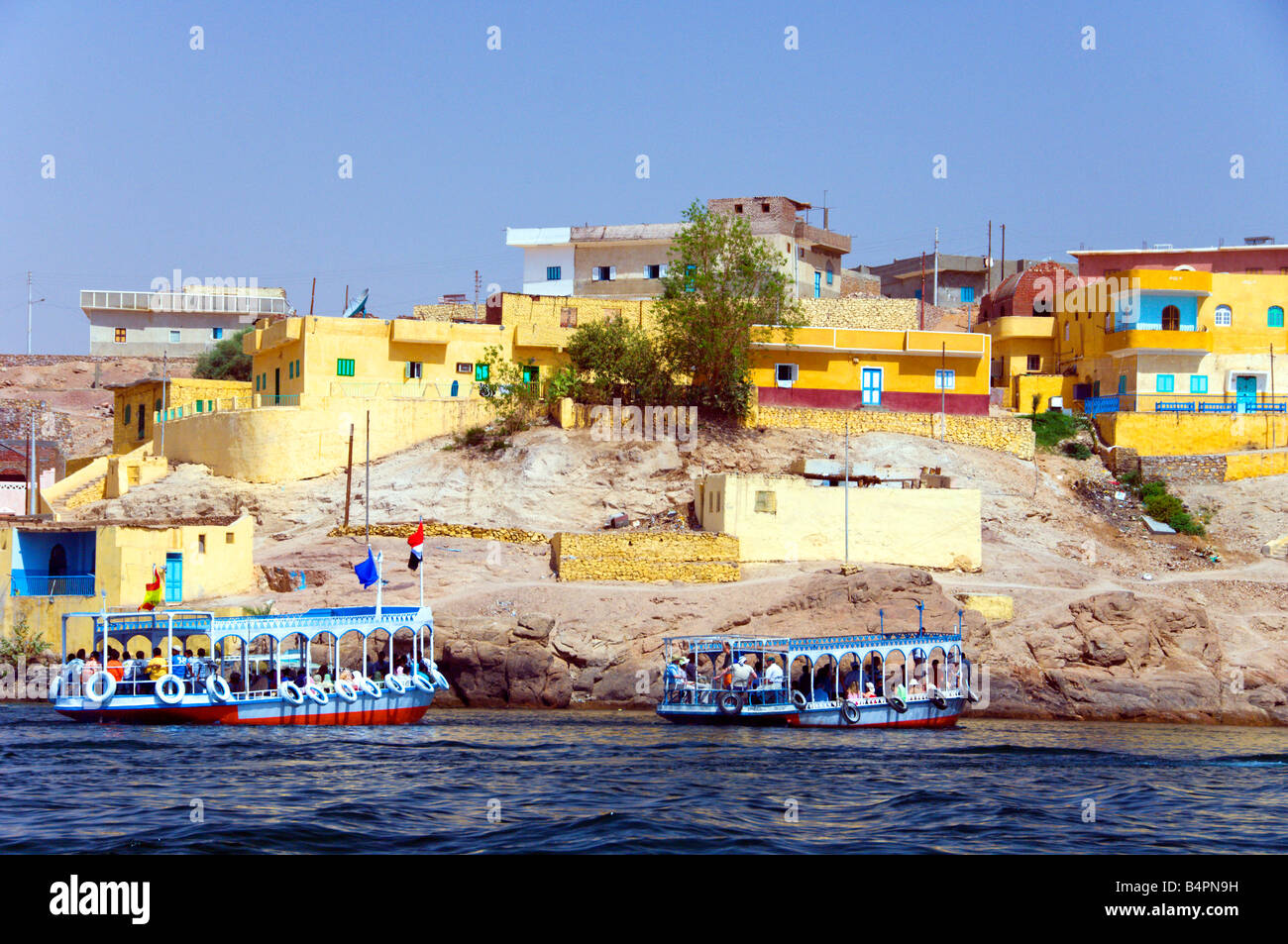 Small excursion boats take tourists out to the island Temple of Phillae ...