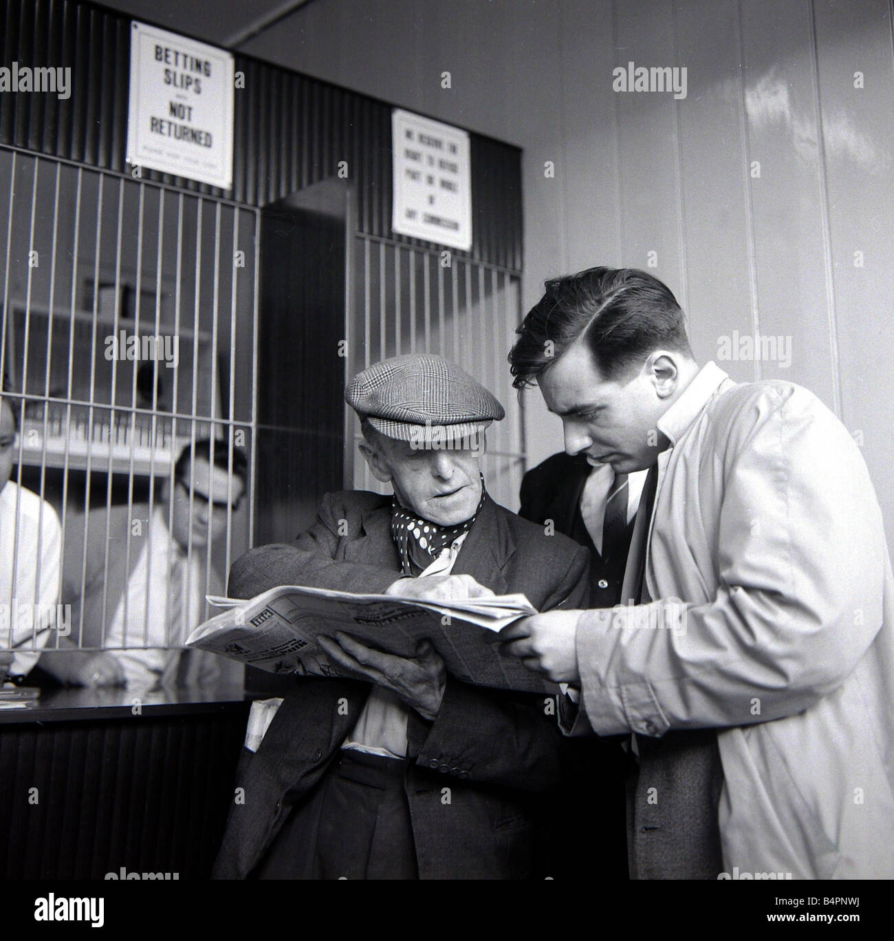 Punters studying the form guide before placing a bet at William Massey ...