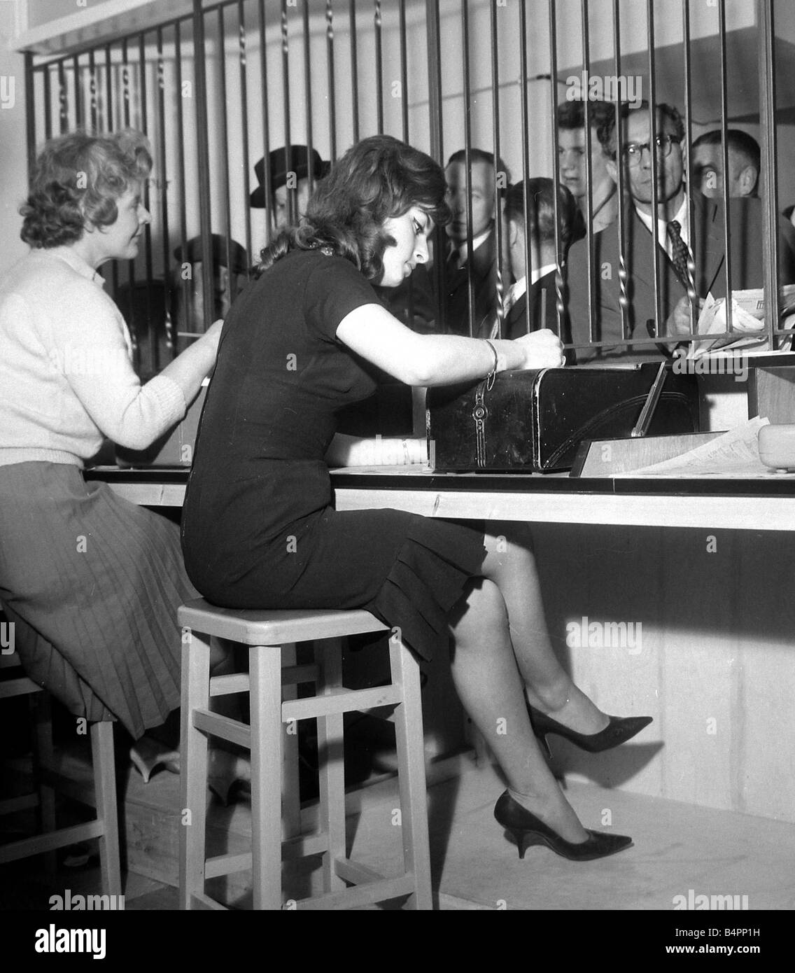 Bookies clerks taking bets from punters at a busy betting shop in Soho ...