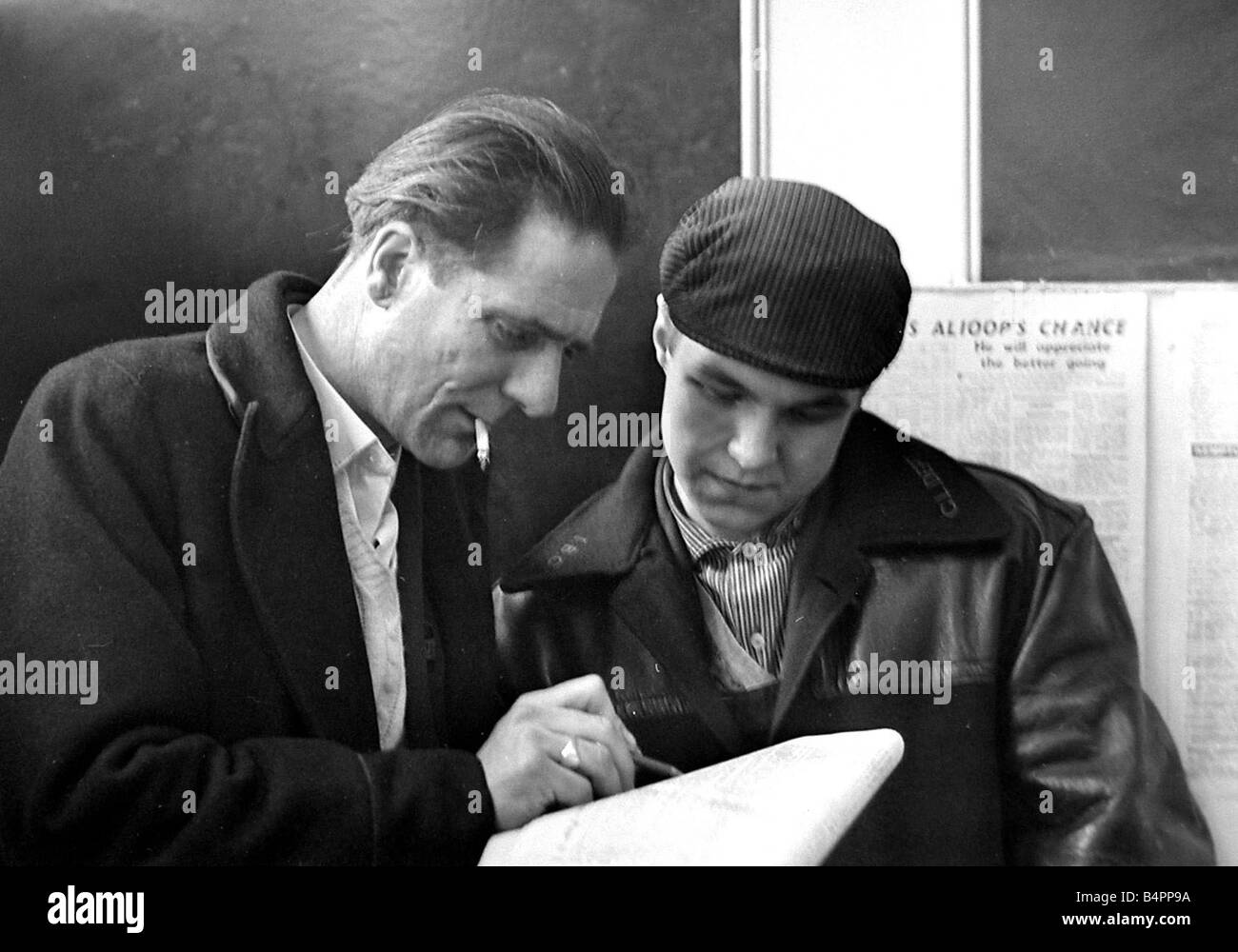 Punters studying the form guide before placing their bets at a race ...