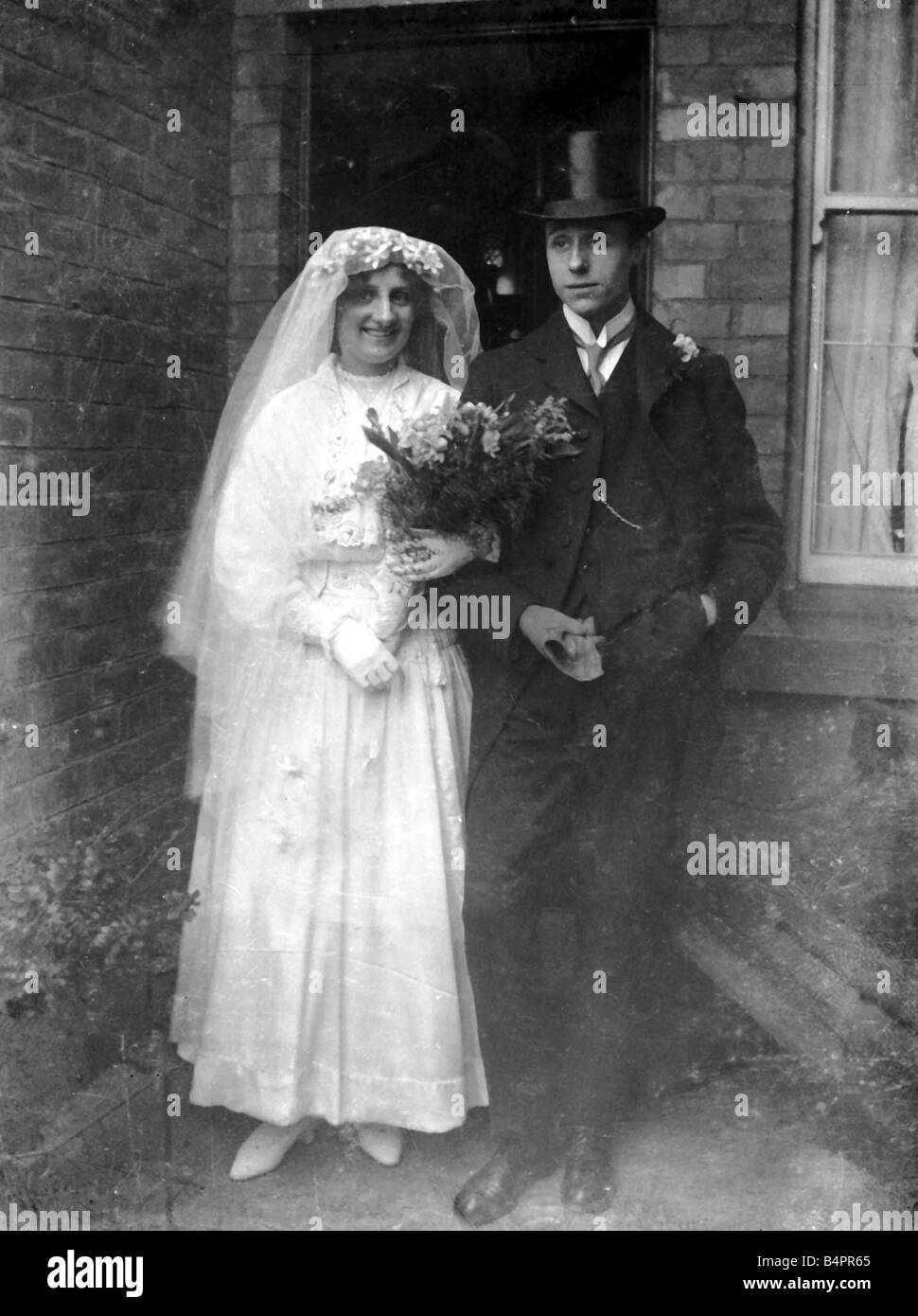 An old time wedding circa 1925 A bride and groom pose outside their ...