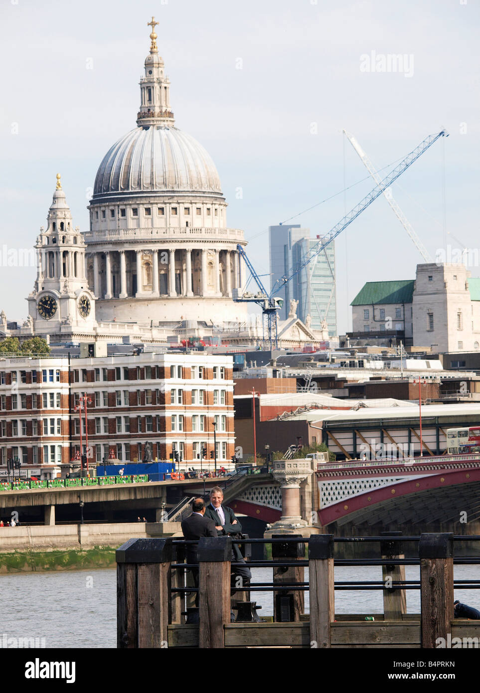 TWO MEN TALKING ON JETTY RIVER THAMES AND ST PAULS IN BACKGROUND LONDON ...