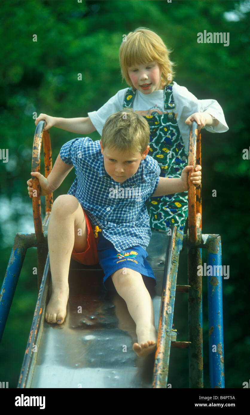two young boys together on a slide Stock Photo - Alamy