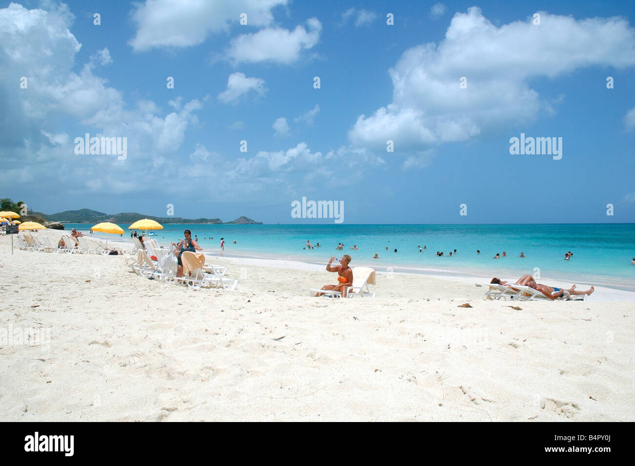 people enjoying the beautiful caribbean beach on the shoreline of st ...