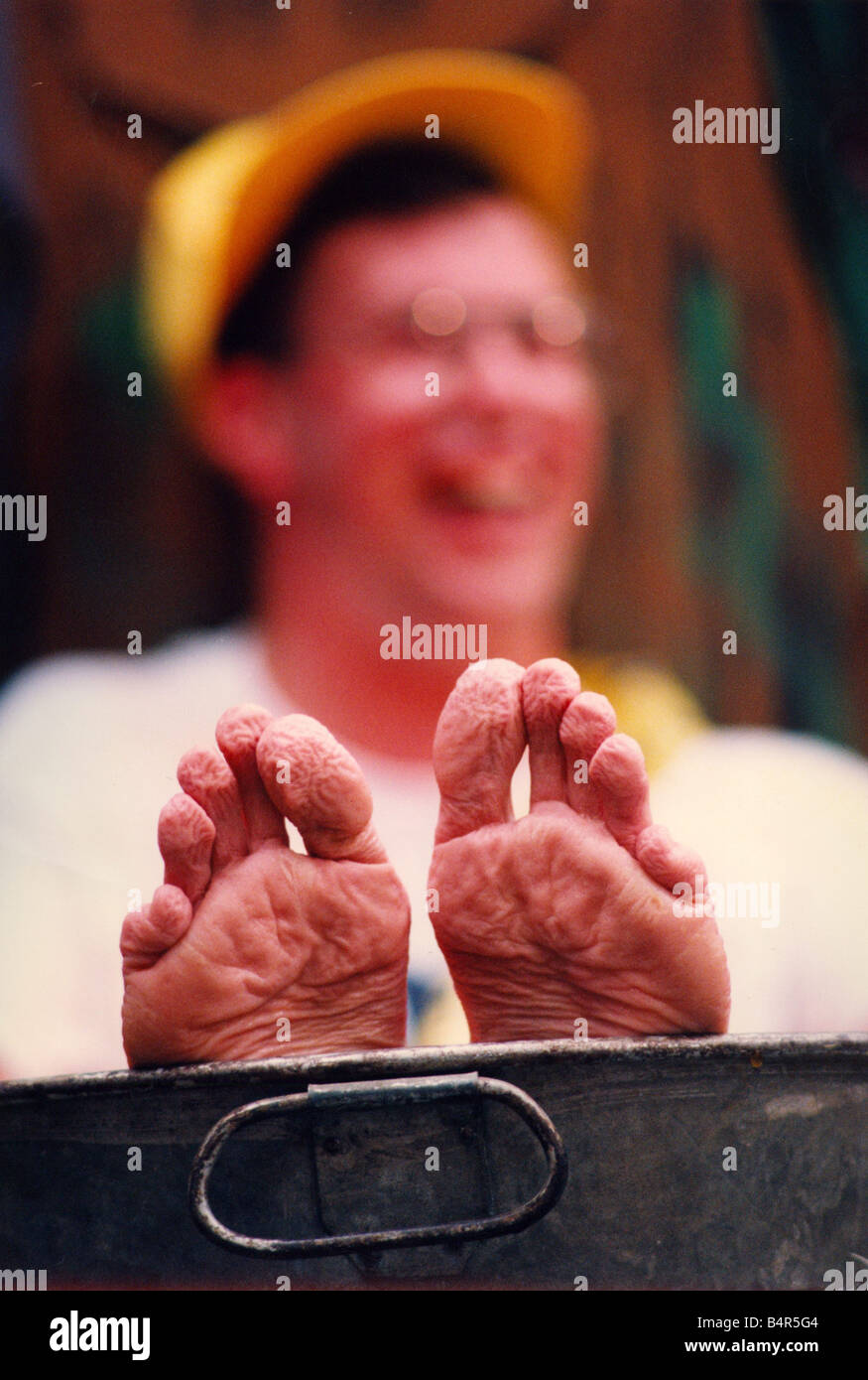 A mans feet are wrinkled from sitting in a bath of custard for charity ...
