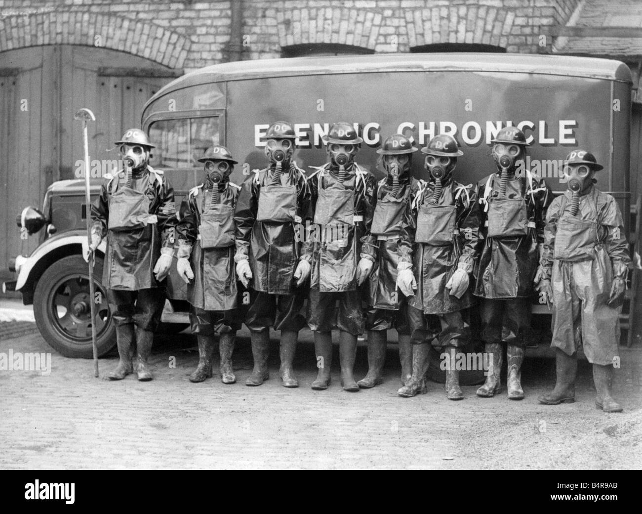 Air raid precautions Men wearing World War Two gas masks and protective ...