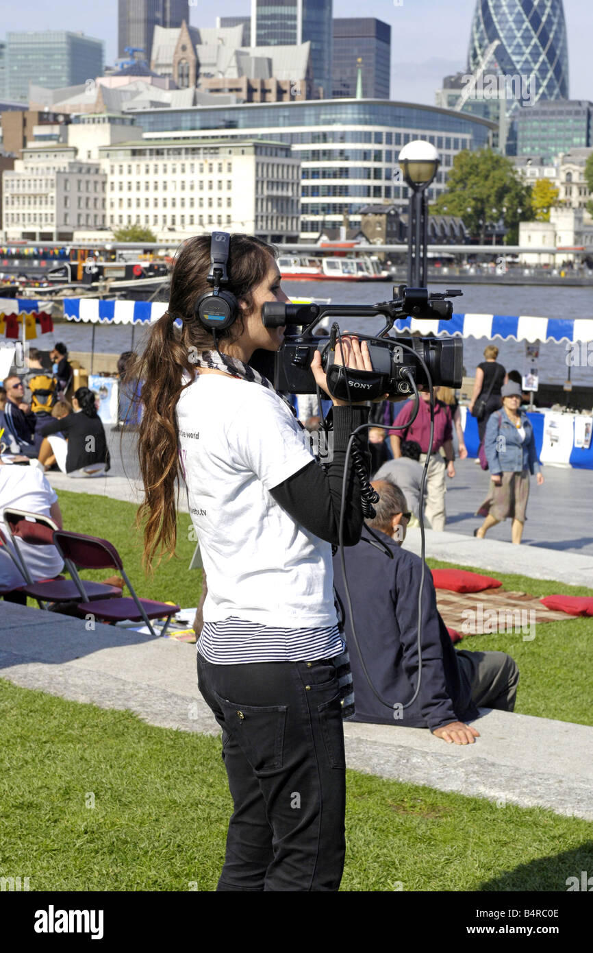 A Female film school student uses a video camera to capture scenes of ...