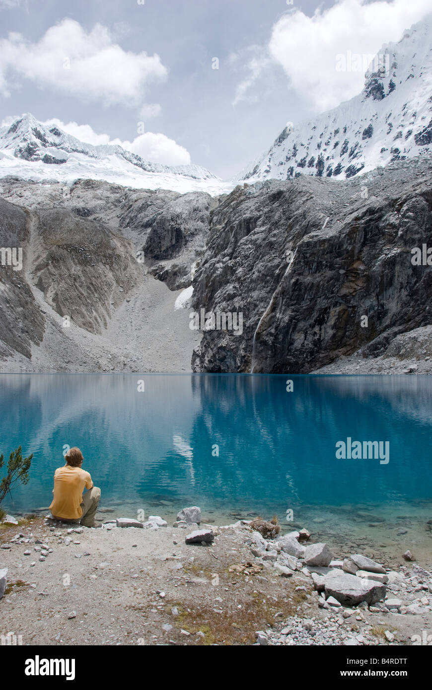 Young backpacker looks out across Laguna 69 in the Peruvian Andes Stock ...