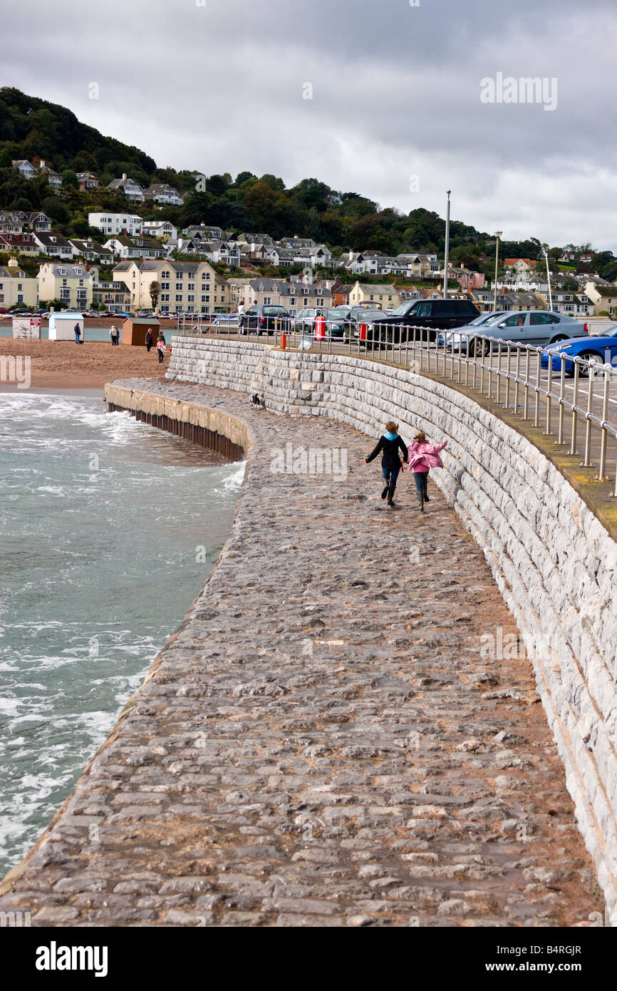 Two girls running along the sea wall "Teignmouth Devon" UK Stock Photo ...