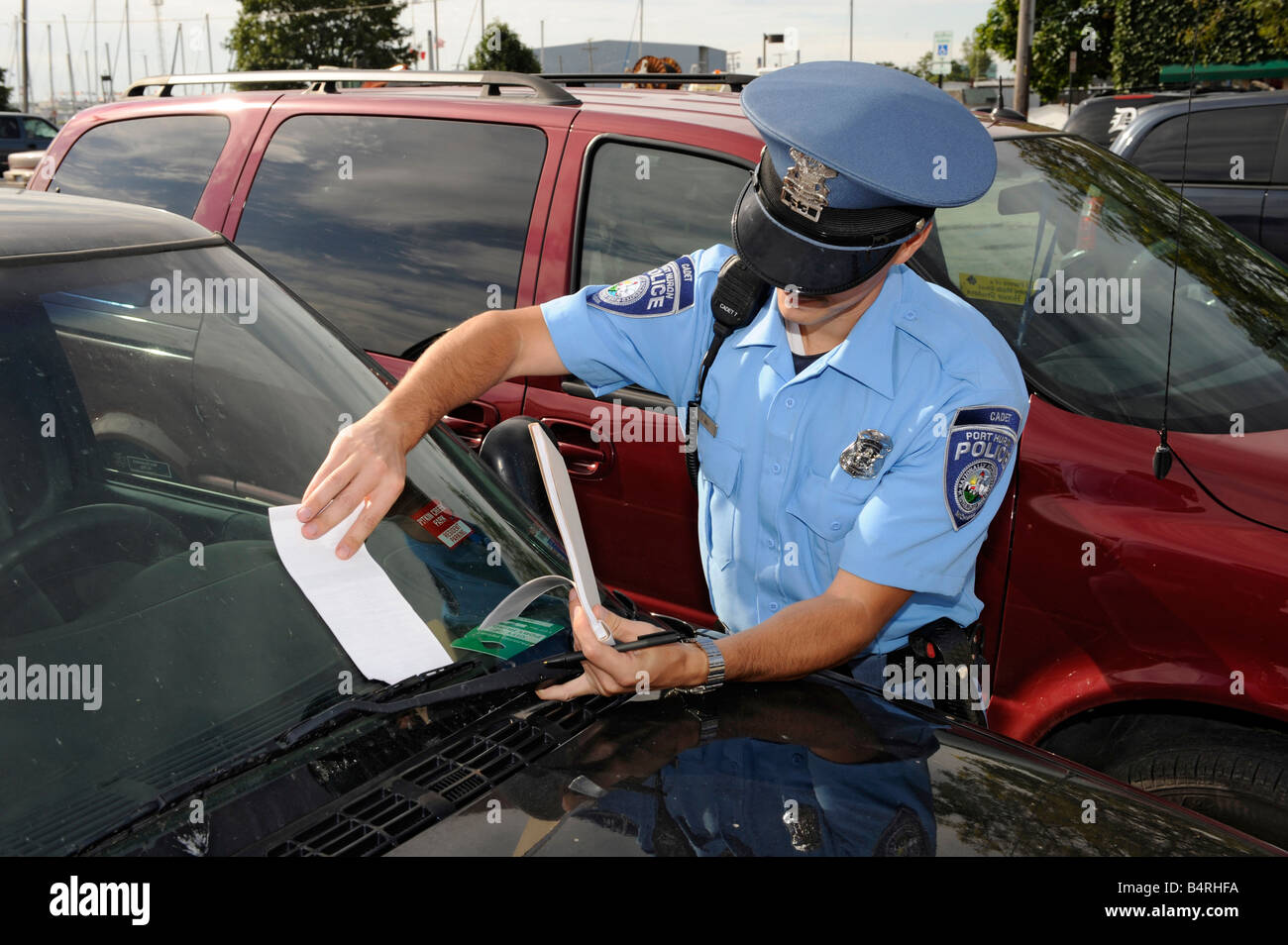 Police officer writes a ticket for parking violation Stock Photo - Alamy