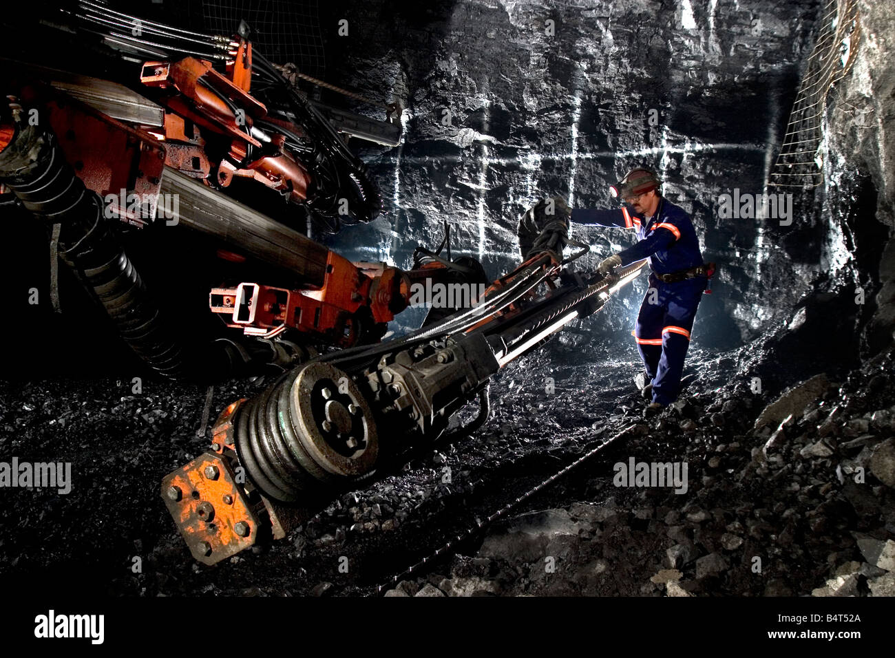 Mining engineer setting up jumbo drill before rock bolting during new ...