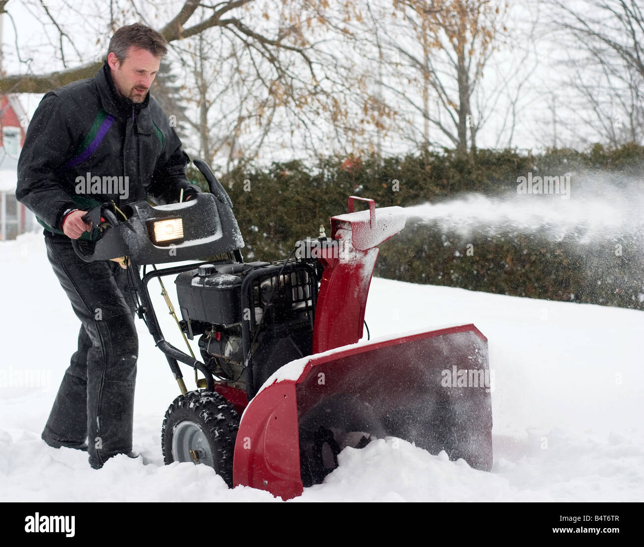 man using snow blower during winter storm Stock Photo - Alamy