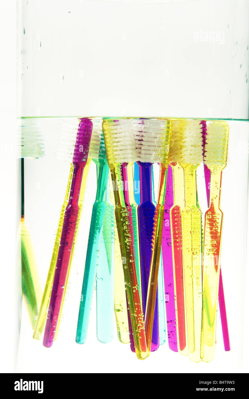 close up of submerged and floating brightly coloured toothbrushes in ...