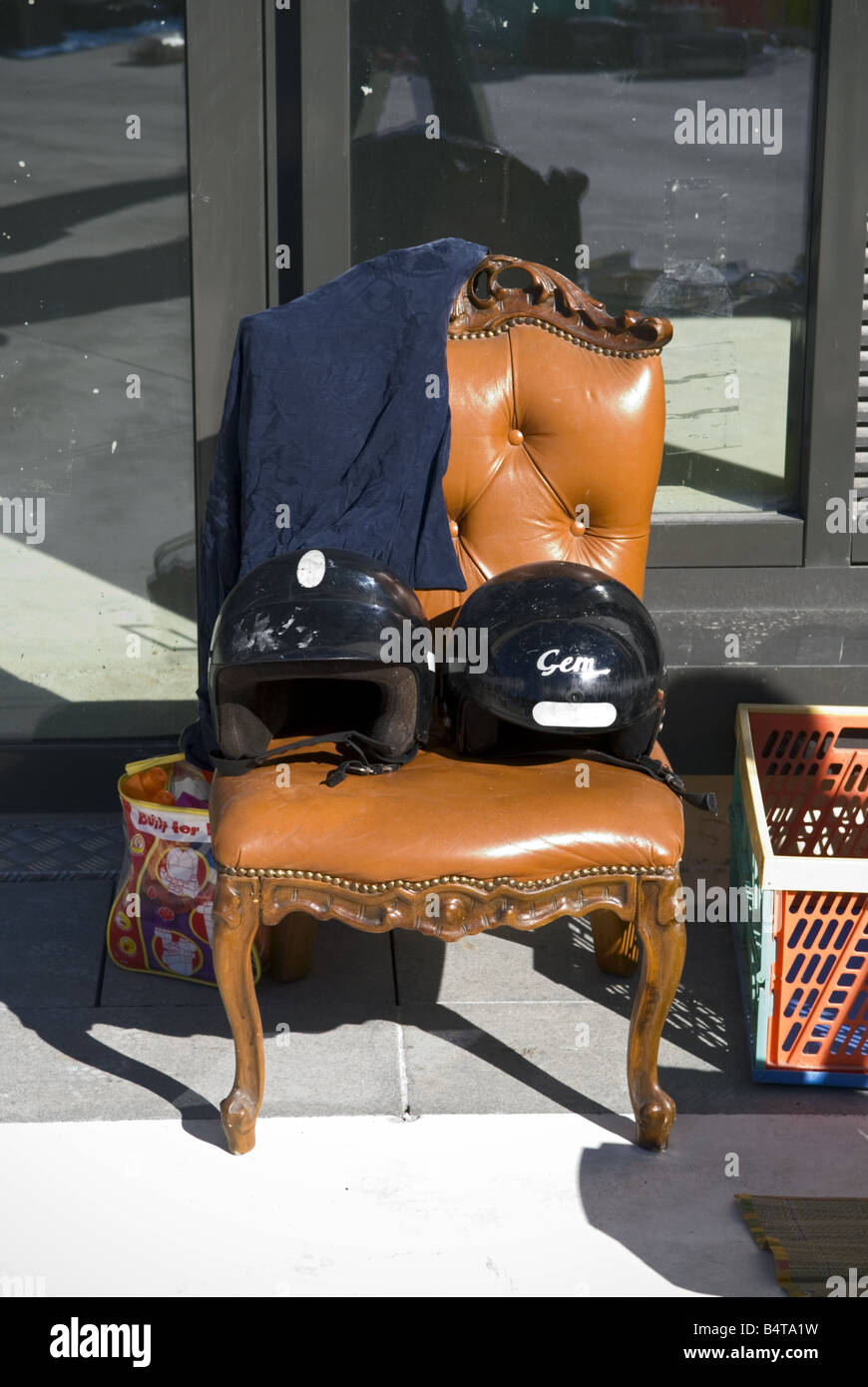 ornate antique chair with two motorcycle helmets at a flea market Stock ...