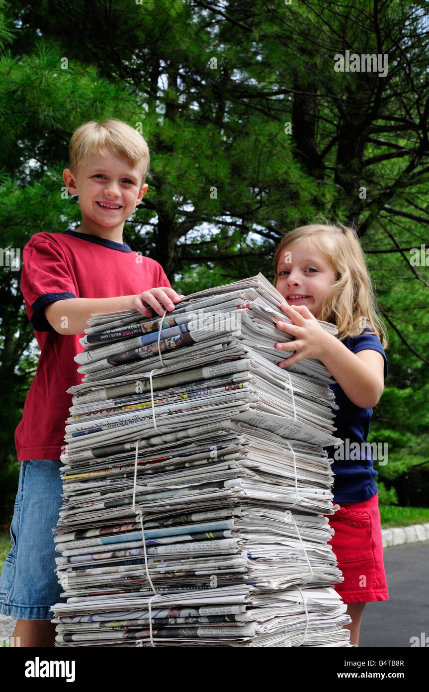 Children stacking newspapers for paper recycling Stock Photo - Alamy