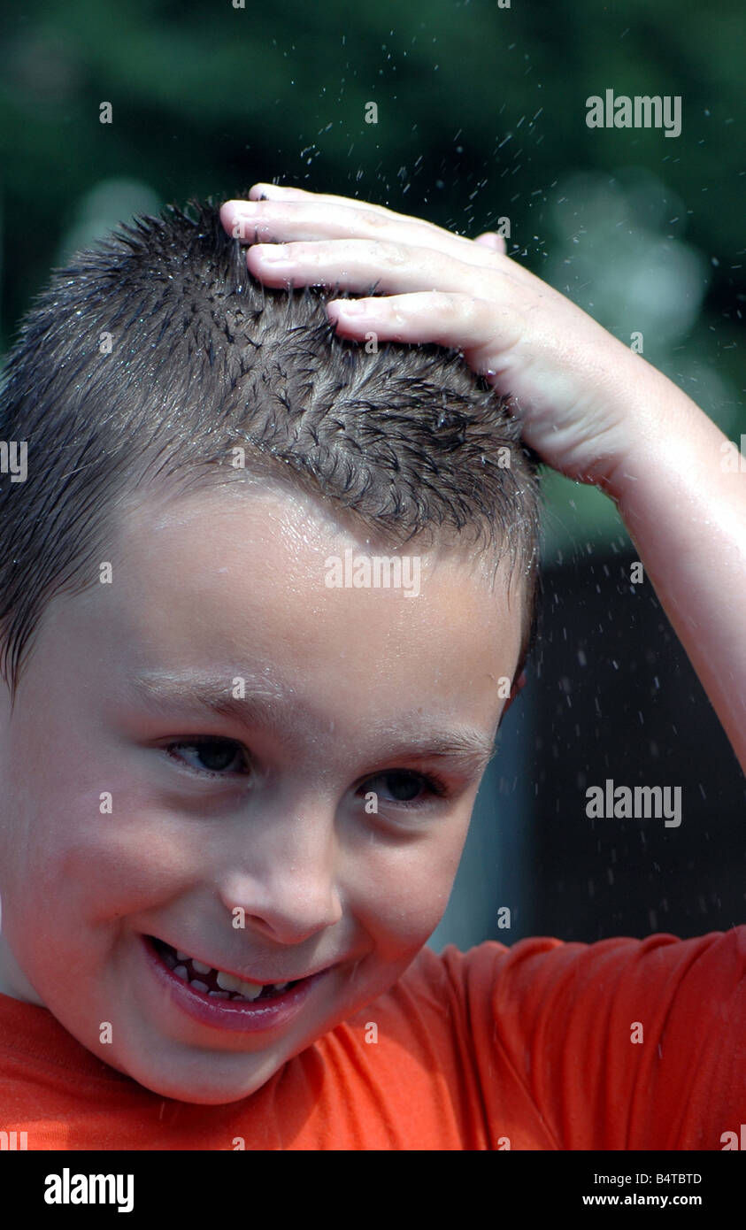 A boy brushing water off his hair with his hand Stock Photo - Alamy