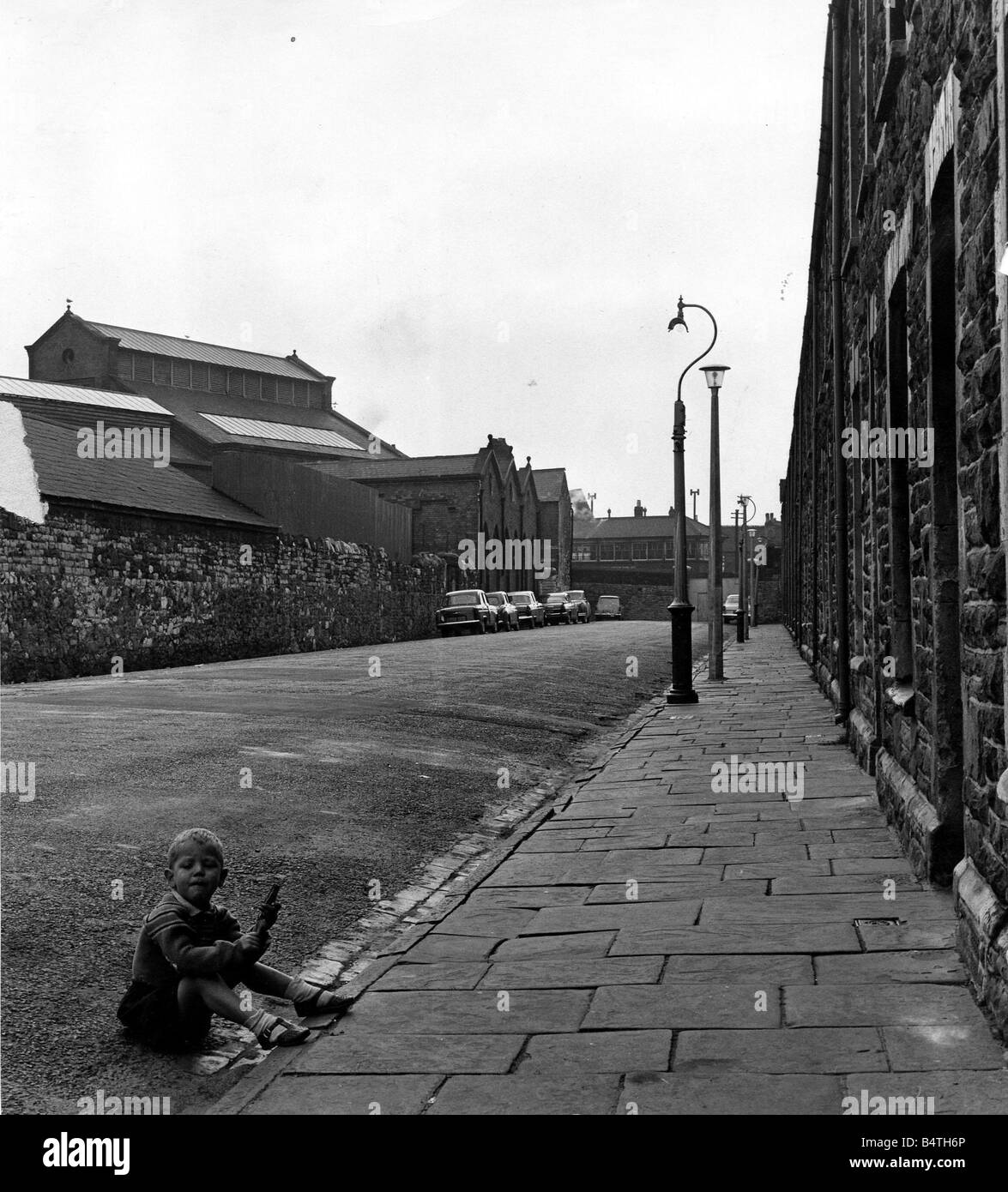Cardiff Old Adamsdown A young child sits in the gutter in Cycle Street ...