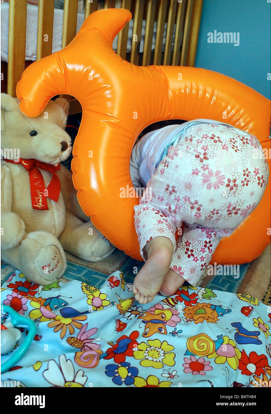 Picture taken for baby supplement shows baby in cot crawling around ...