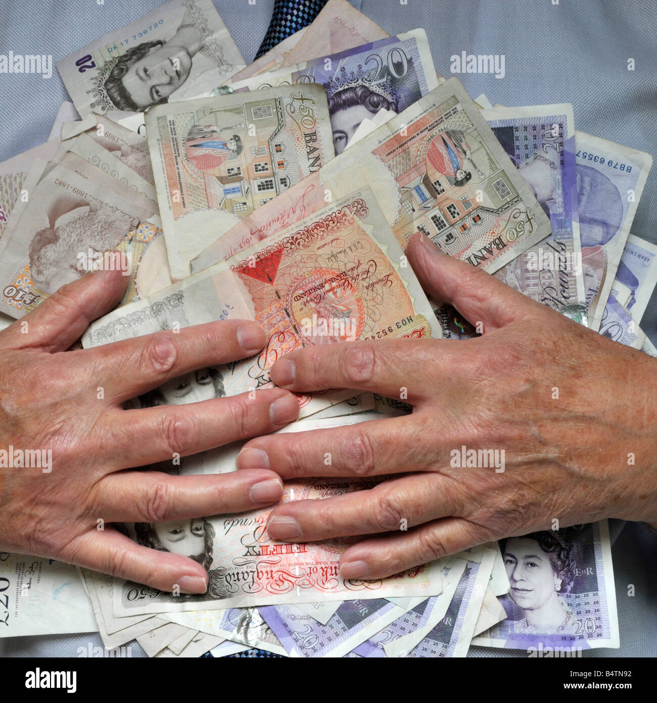 Hand clutching money sterling hi-res stock photography and images - Alamy
