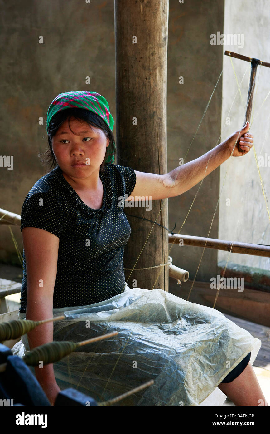 White Hmong tribeswoman weaving flax at a village in Ha Giang Province ...