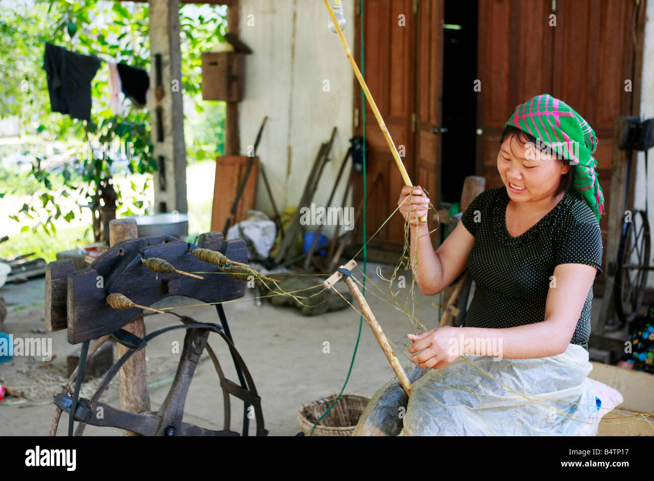 White Hmong tribeswoman weaving flax at a village in Ha Giang Province ...