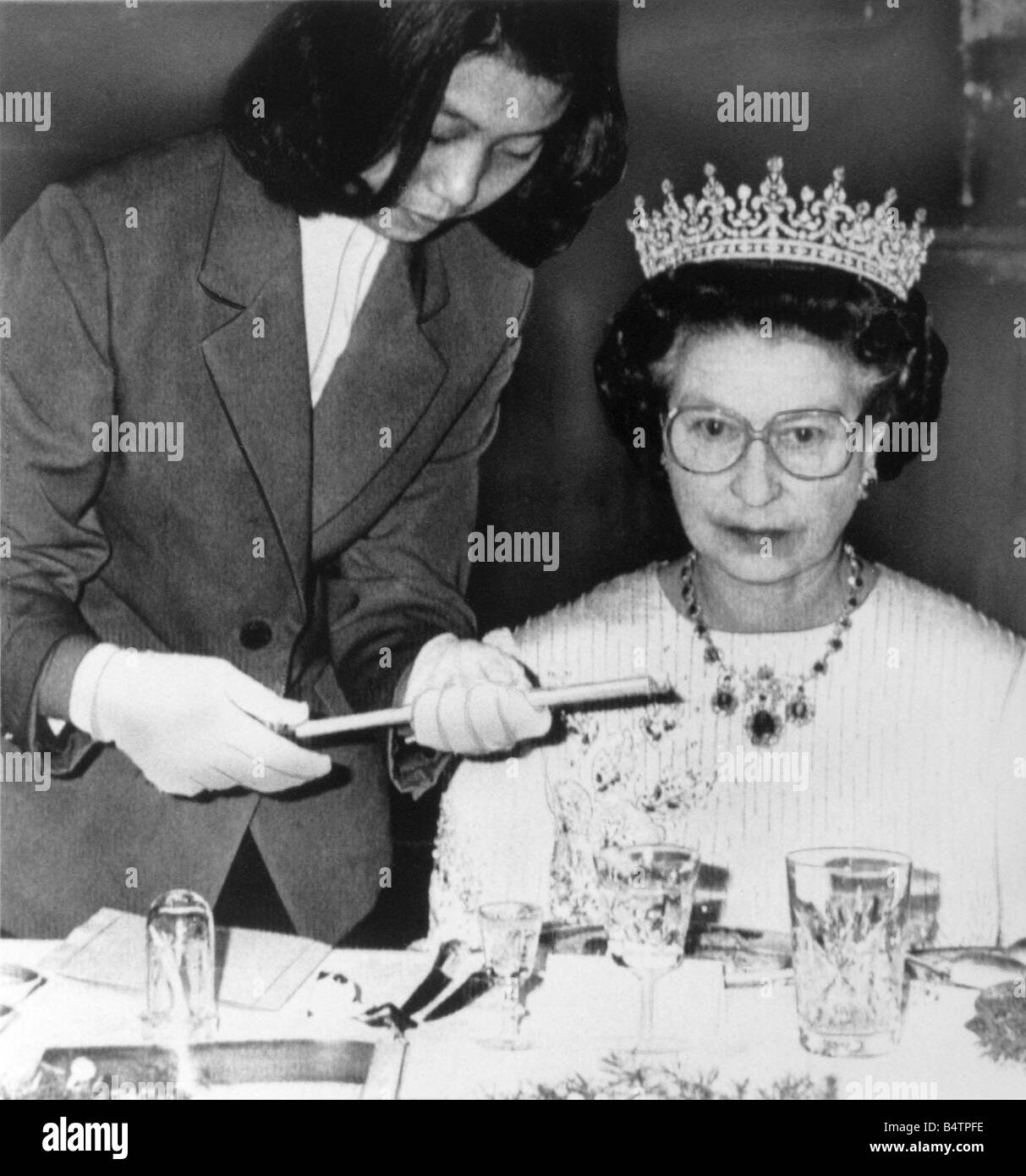 The Queen in China at banquet in Peking Being handed chopsticks to eat ...