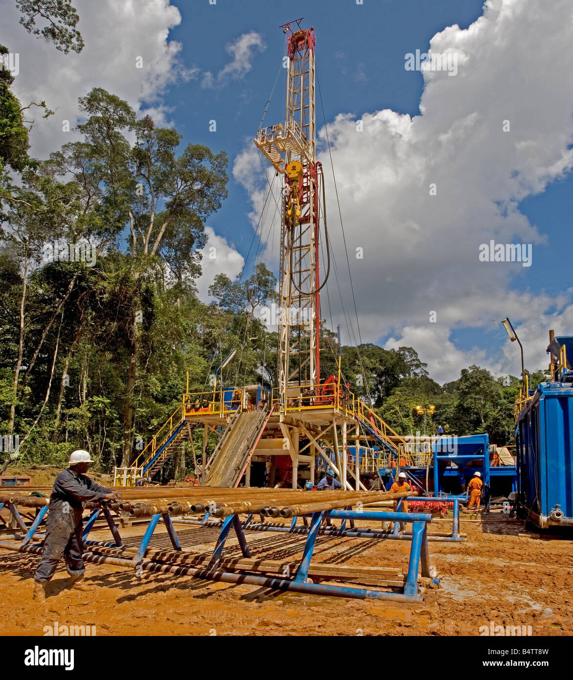 Remote onshore oil well and drillrig site in rainforest with crewmen ...